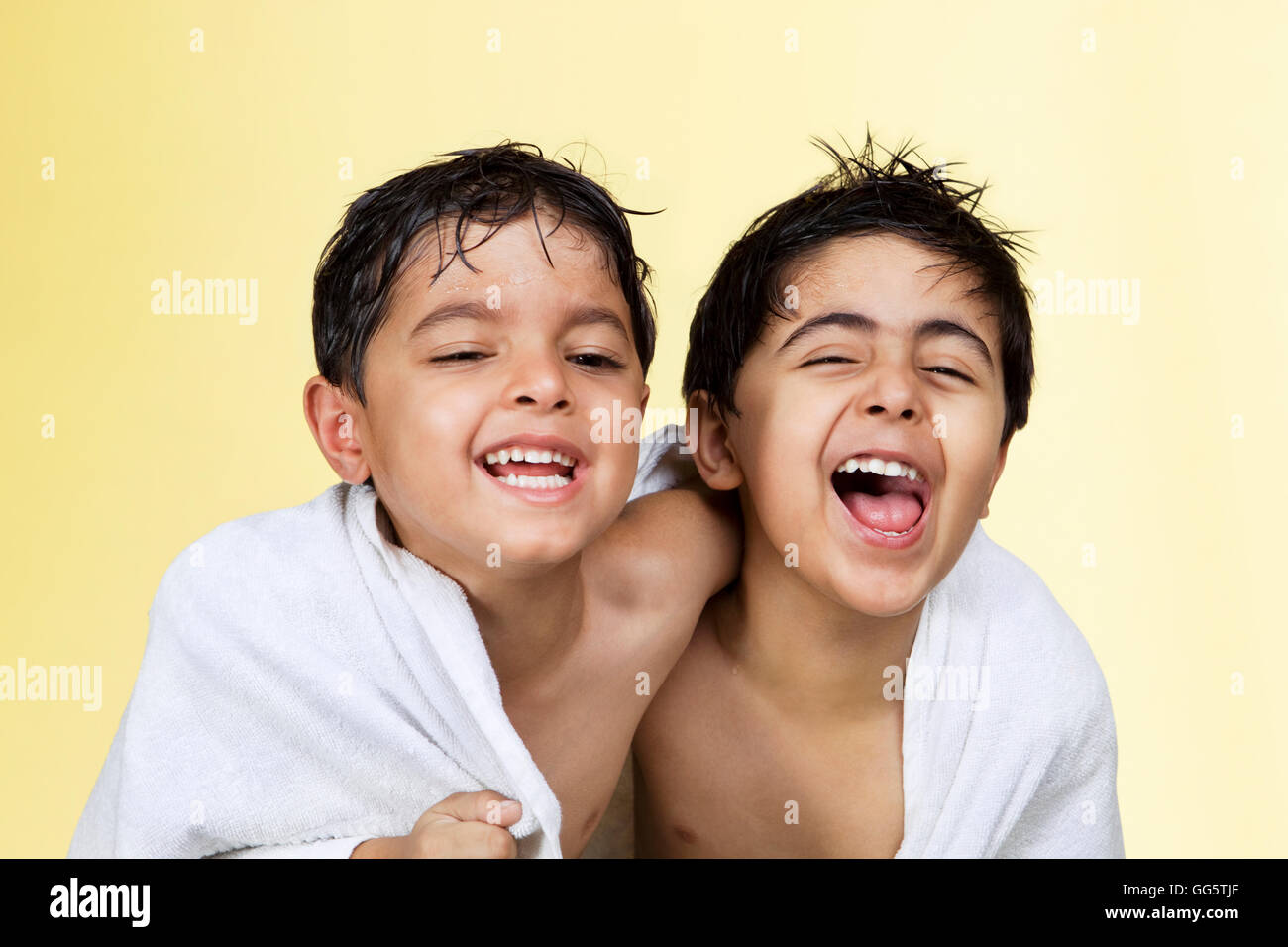 Happy kids wrapped in towels Stock Photo - Alamy