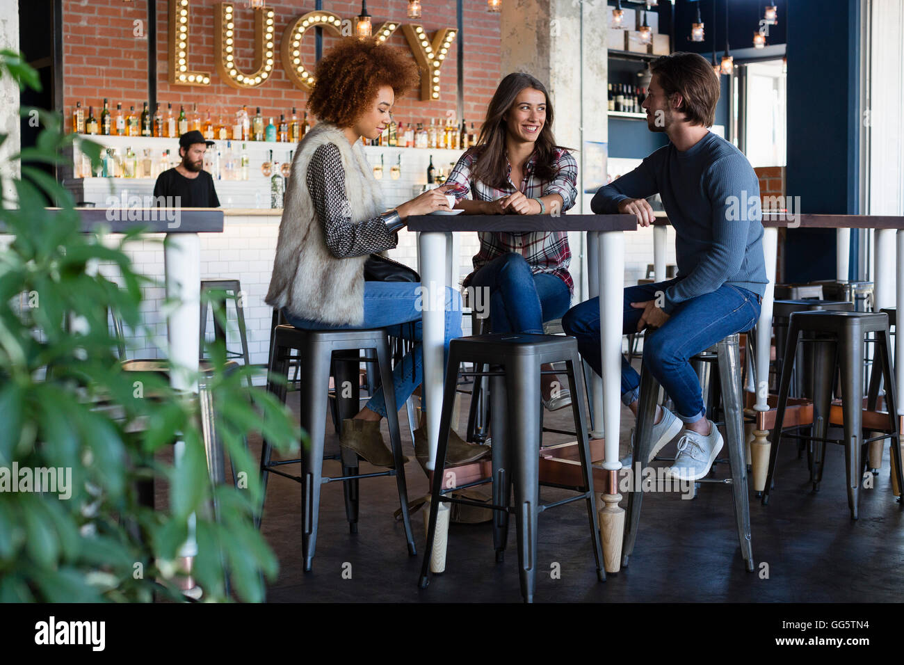 Friends talking at cafe table Stock Photo - Alamy