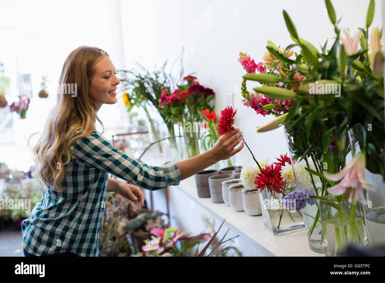 Side profile of a woman holding a flower and smiling Stock Photo - Alamy
