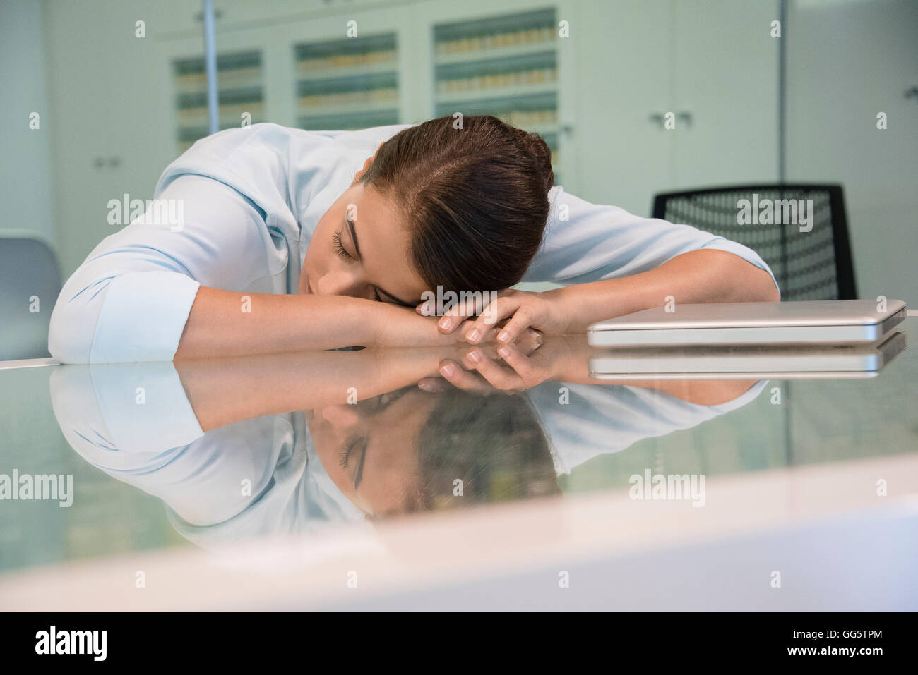 Businesswoman resting her head on table in an office Stock Photo - Alamy