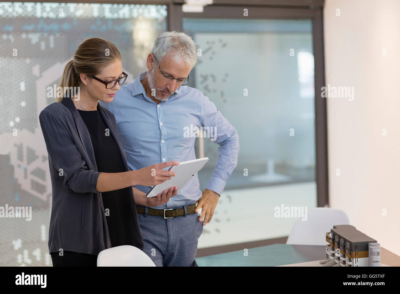 Design professionals using a digital tablet in an office Stock Photo - Alamy