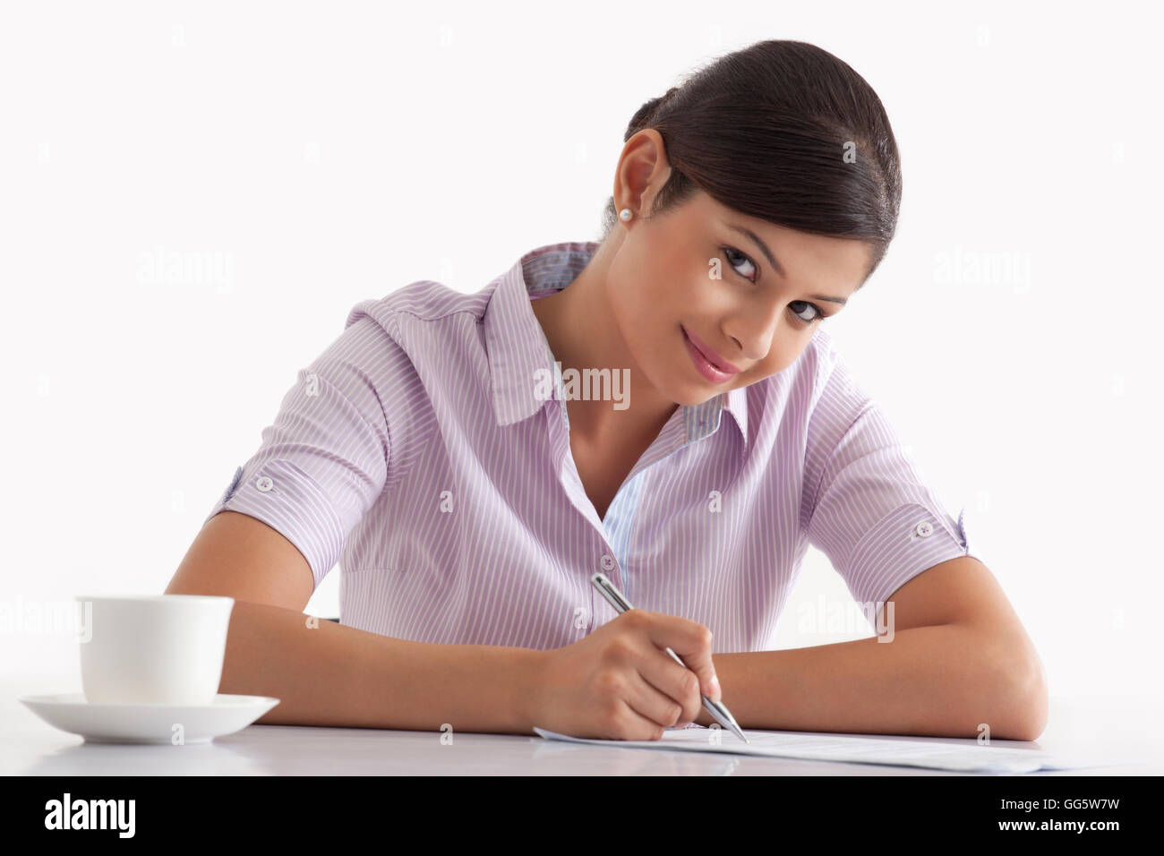 Portrait of smiling female executive writing on paper Stock Photo - Alamy