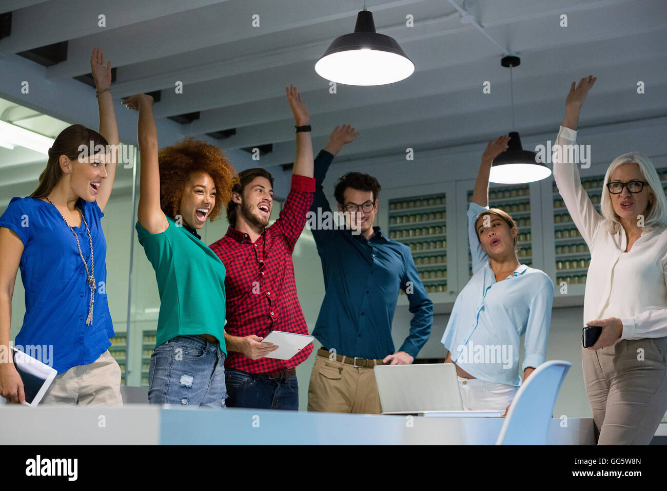 Happy business people cheering in meeting Stock Photo - Alamy