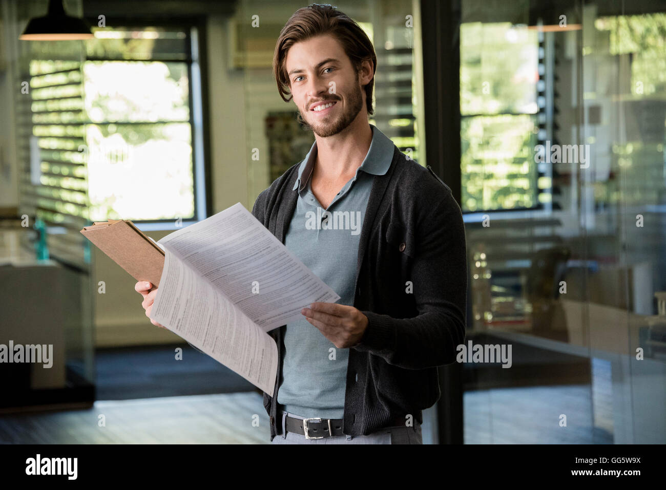 Portrait of a happy man holding a file Stock Photo - Alamy