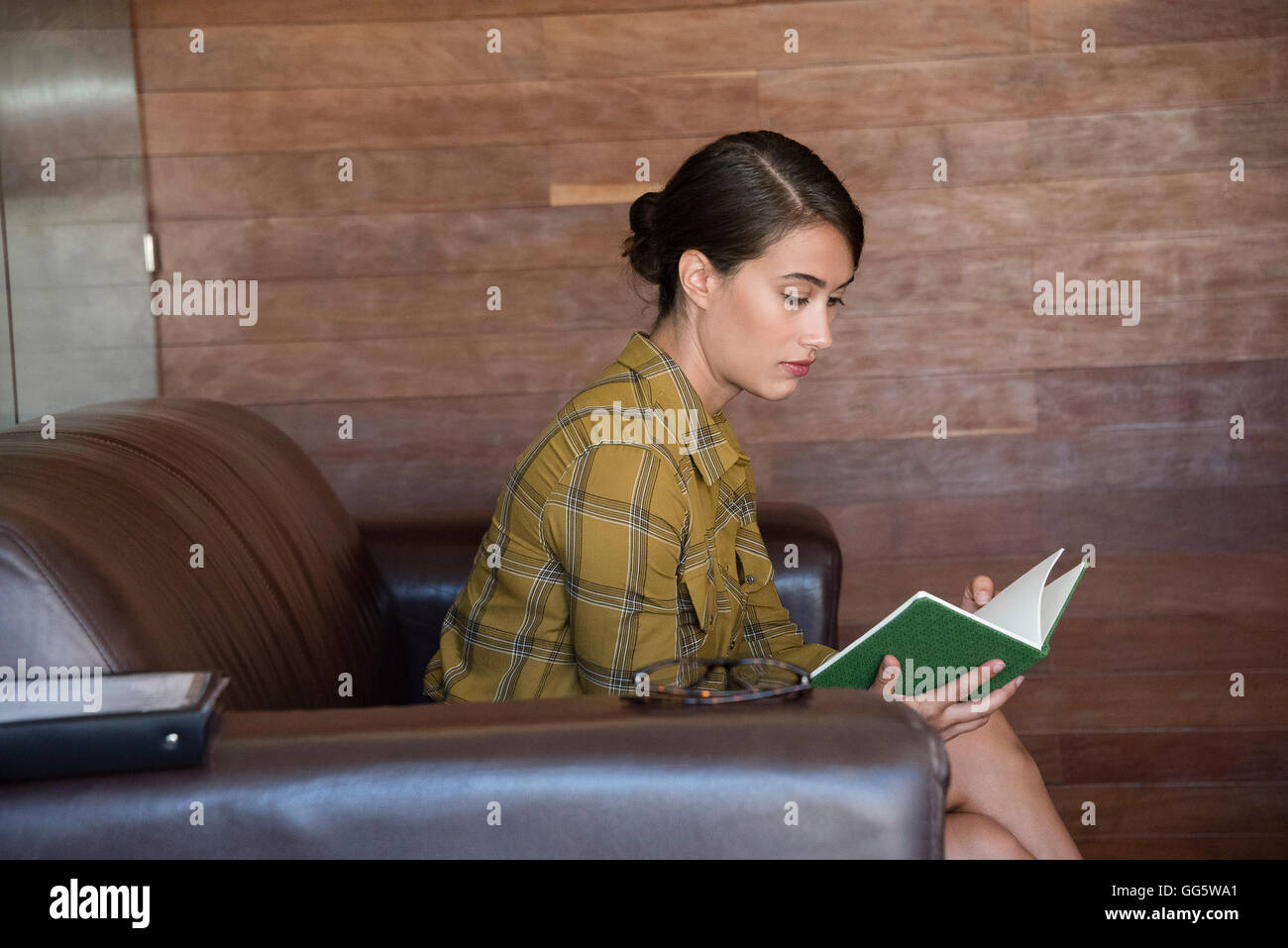 Businesswoman reading a book during office break Stock Photo - Alamy