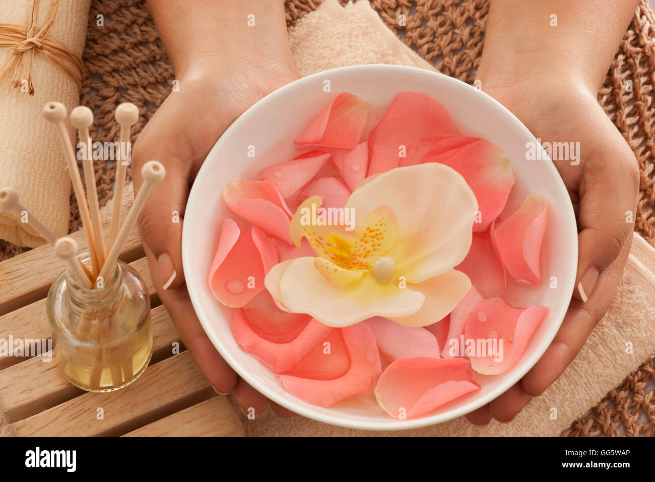 Rose petals and orchid in a bowl with reed diffuser Stock Photo - Alamy
