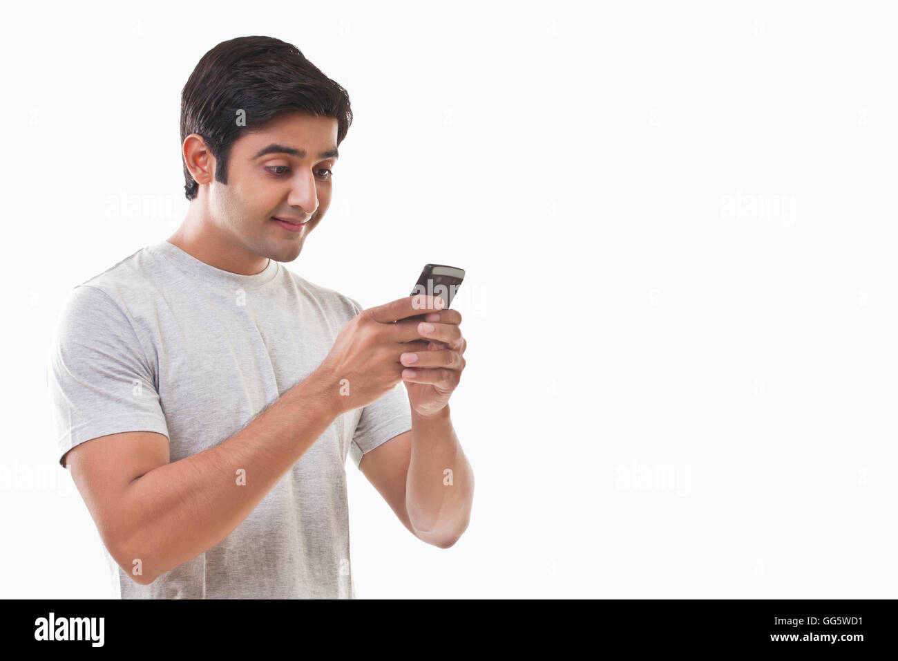 Young man reading text message and smiling Stock Photo - Alamy