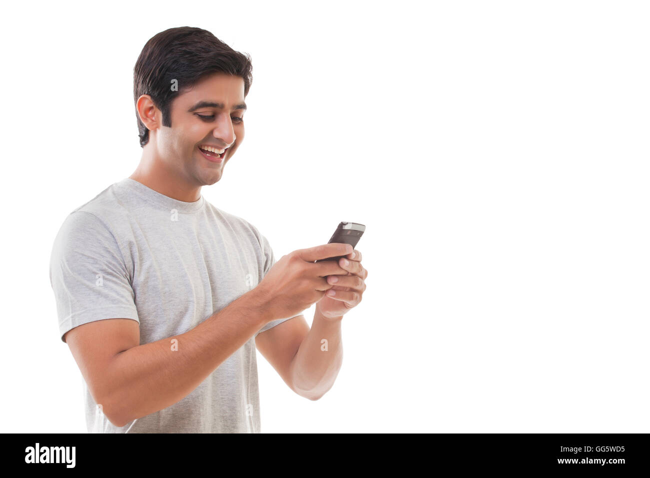 Smiling young man reading text message over white background Stock ...
