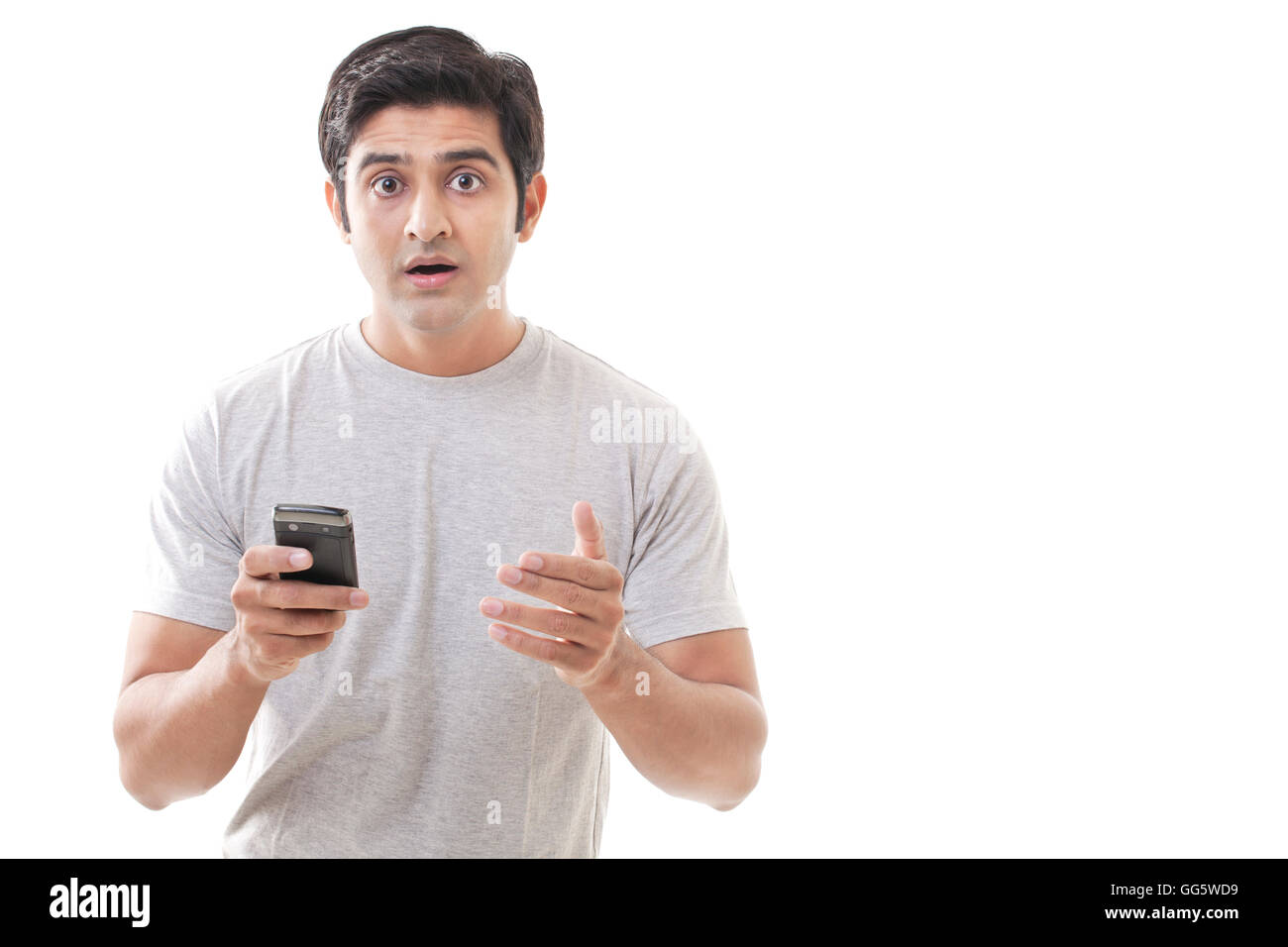 Portrait of surprised young man holding cell phone Stock Photo - Alamy