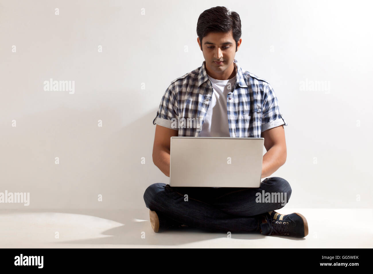 Full length of handsome man using laptop Stock Photo - Alamy