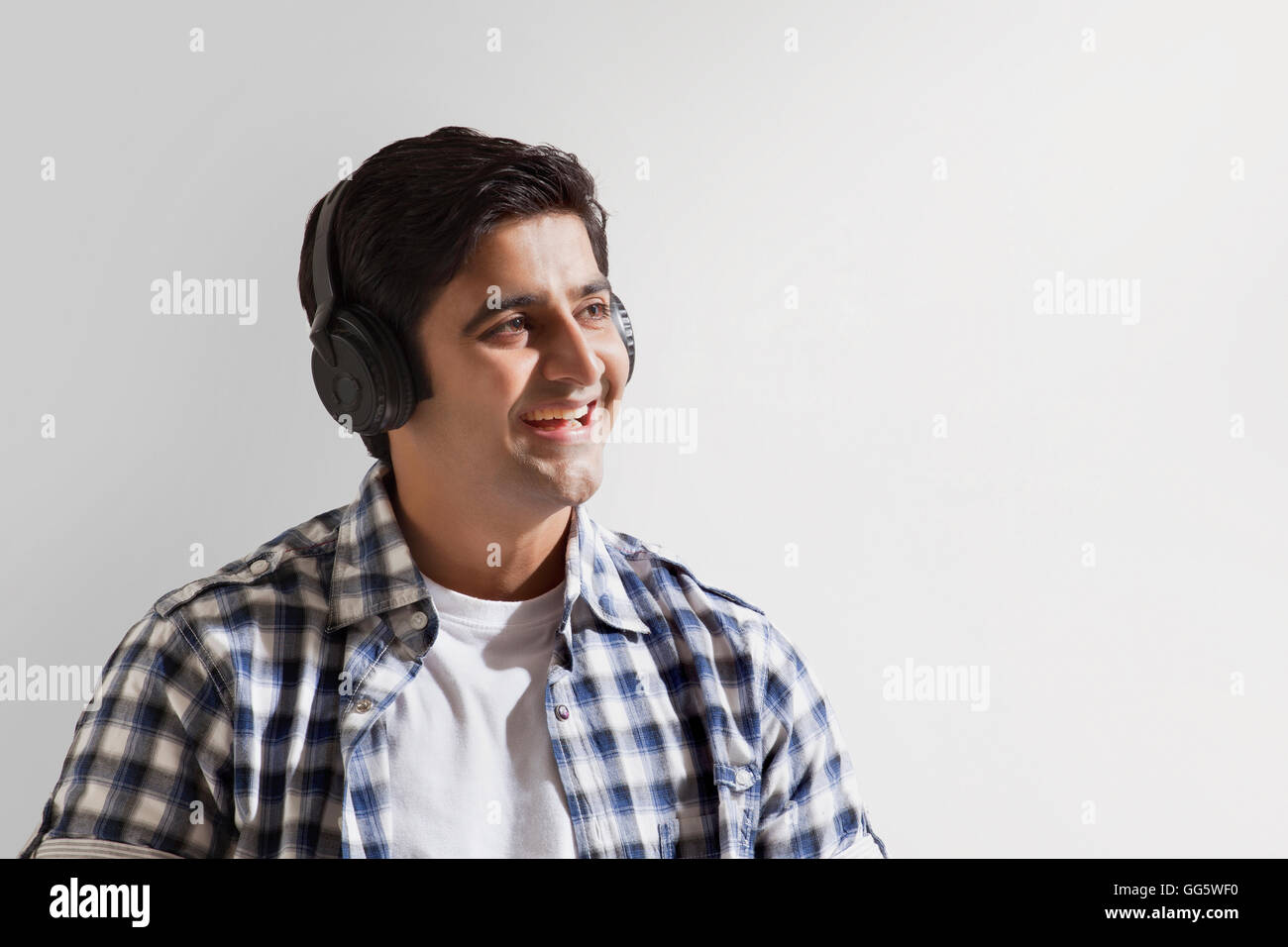 Close-up of smiling young man enjoying music Stock Photo - Alamy