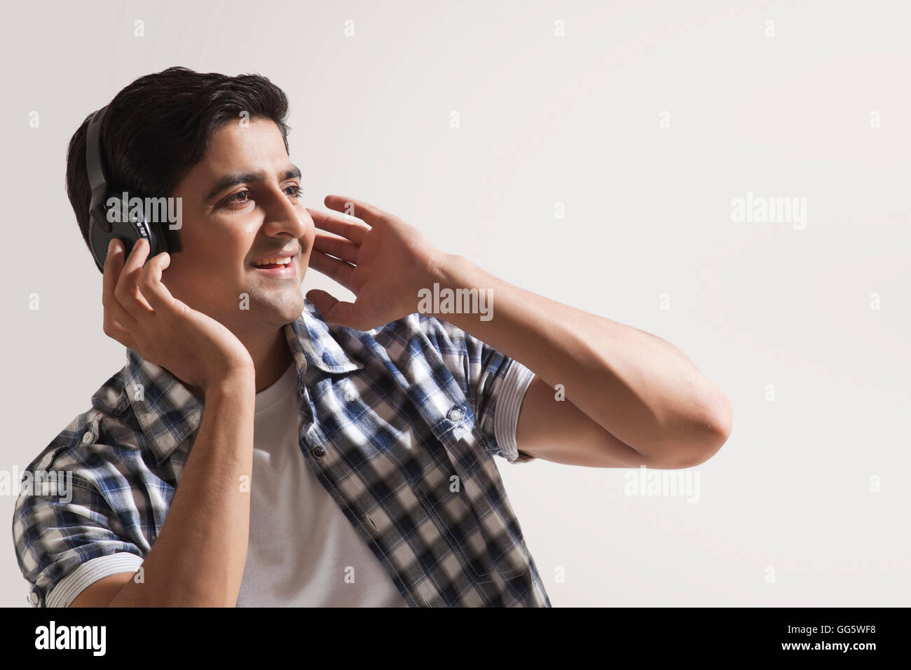 Man looking away while listening to music Stock Photo - Alamy