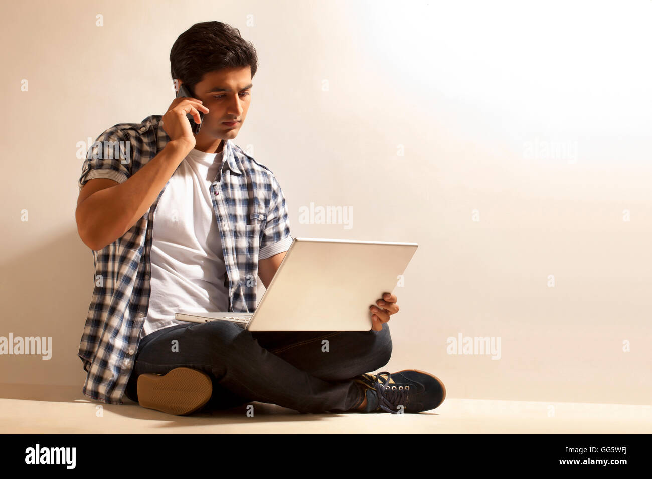 Serious man looking at laptop screen while on call Stock Photo - Alamy