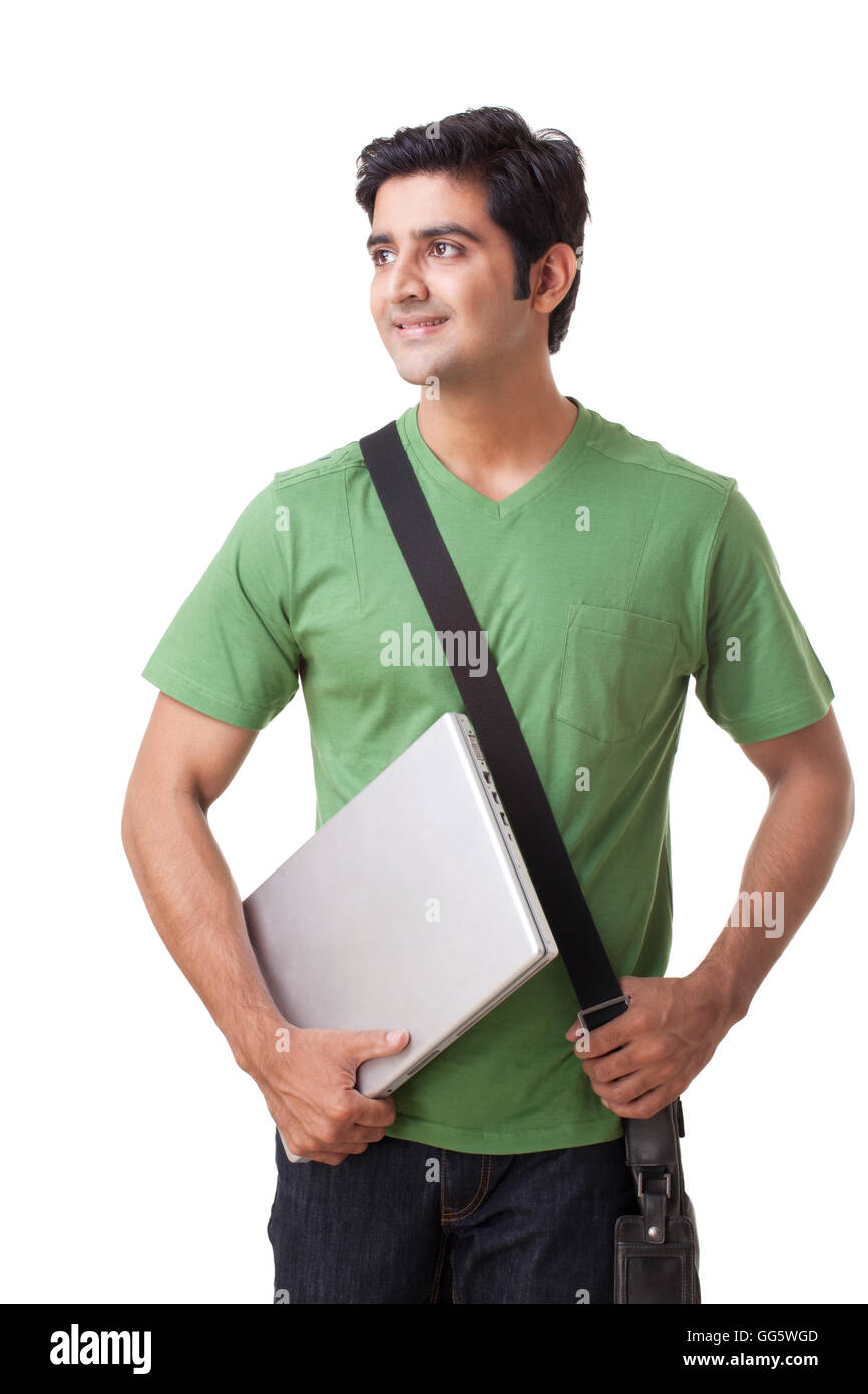 Smiling young man with shoulder bag holding laptop Stock Photo - Alamy