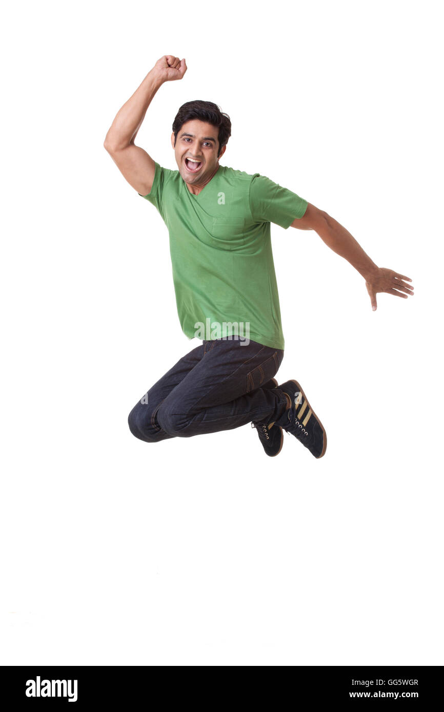 Excited young man jumping over white background Stock Photo - Alamy