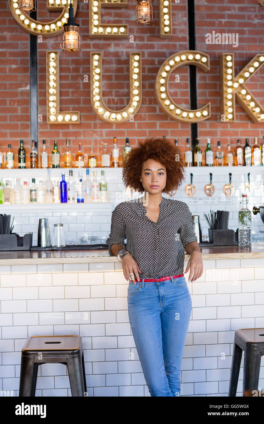 Portrait of a young woman standing at bar counter Stock Photo - Alamy