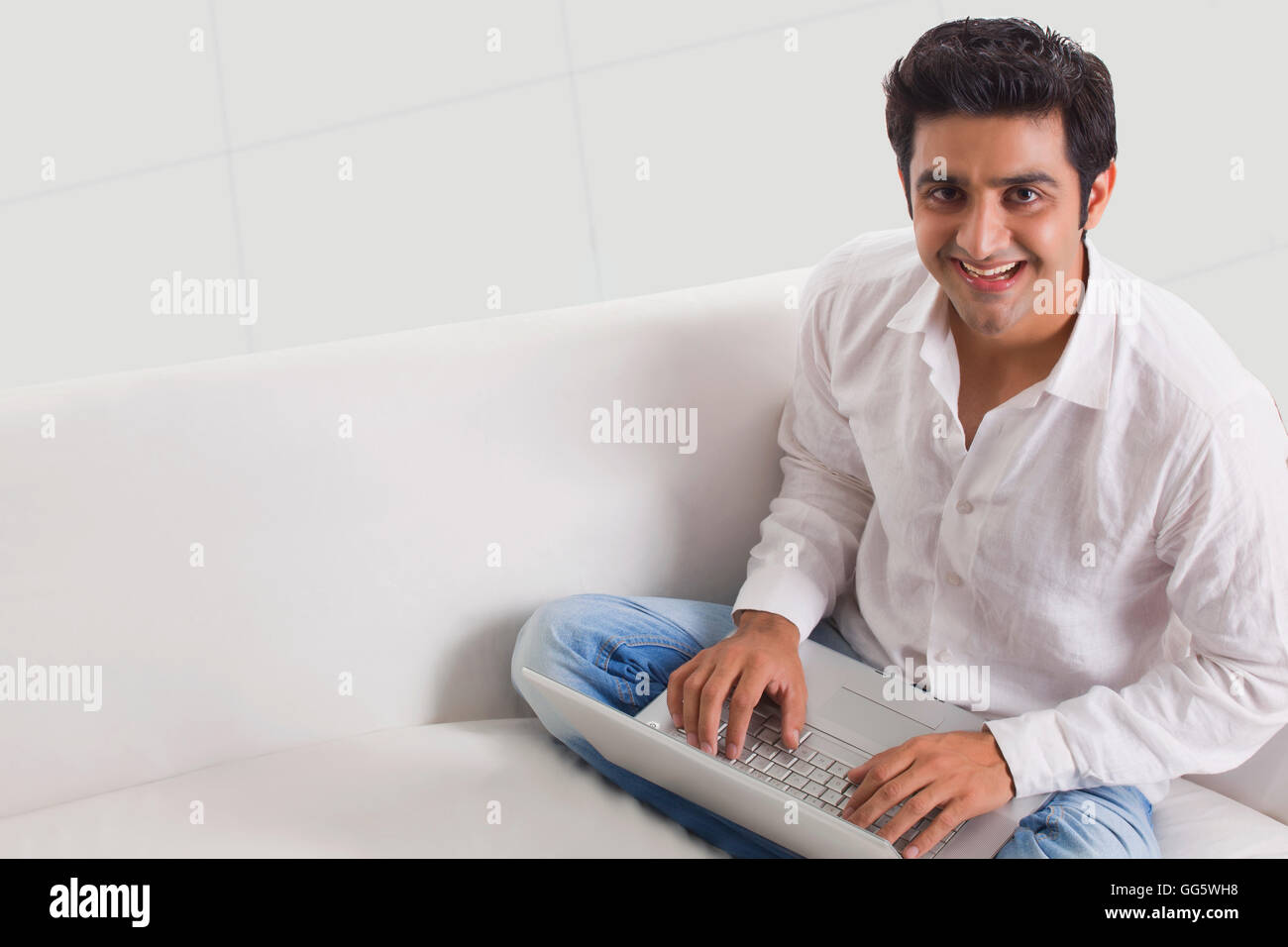Portrait of handsome young man using laptop , smiling Stock Photo - Alamy