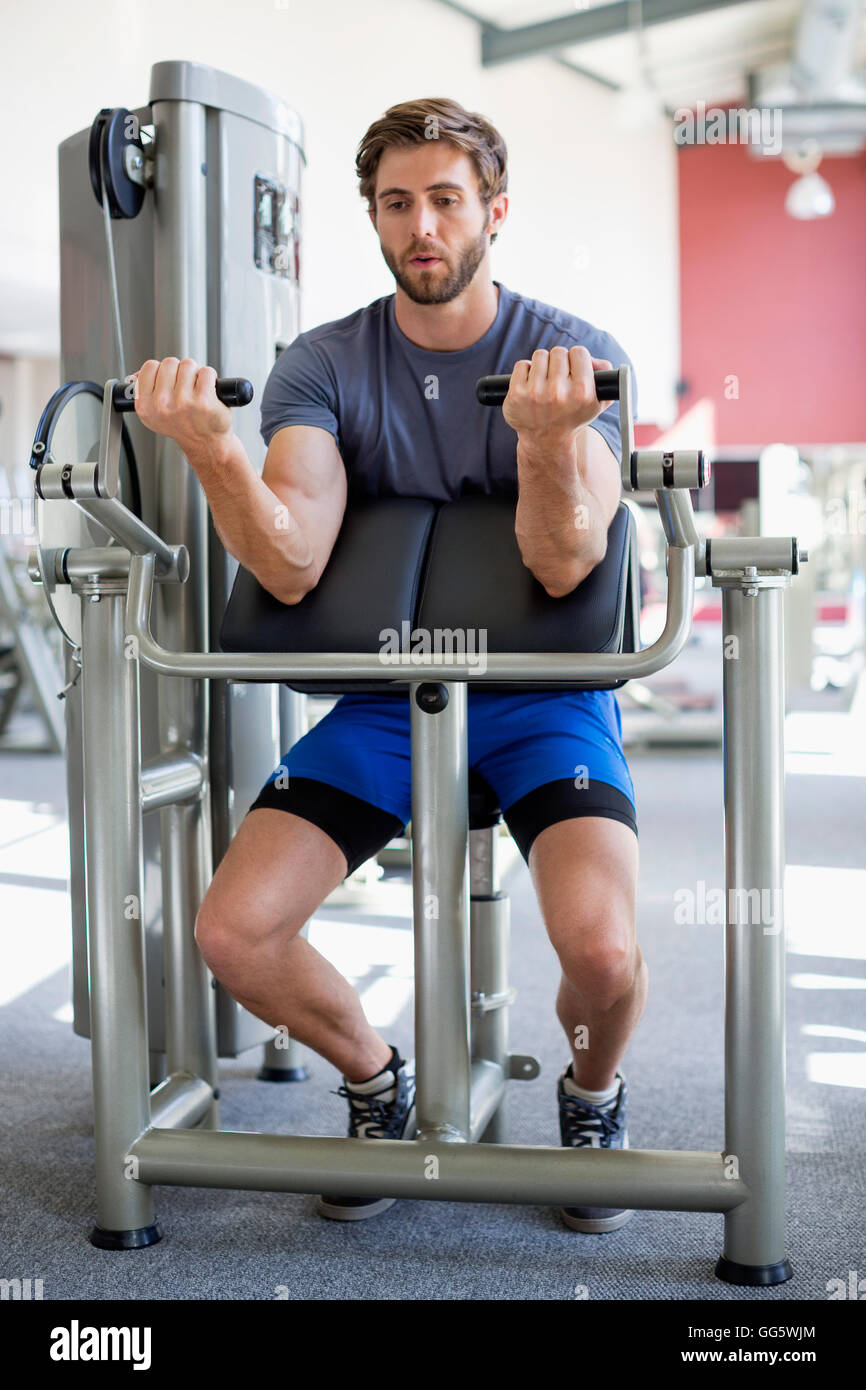 Young man exercising in a gym Stock Photo - Alamy