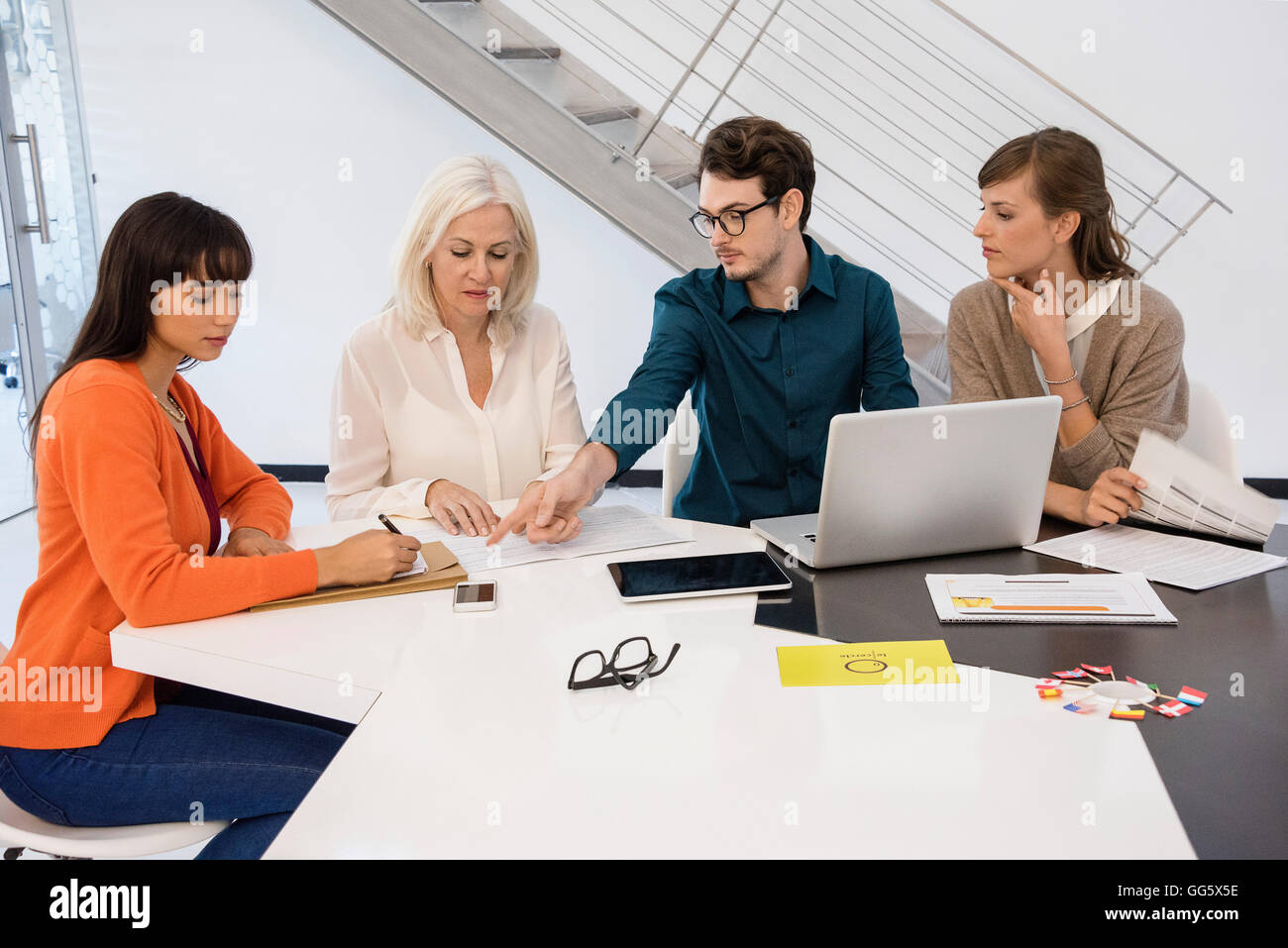 Team of four business people working in an office Stock Photo - Alamy