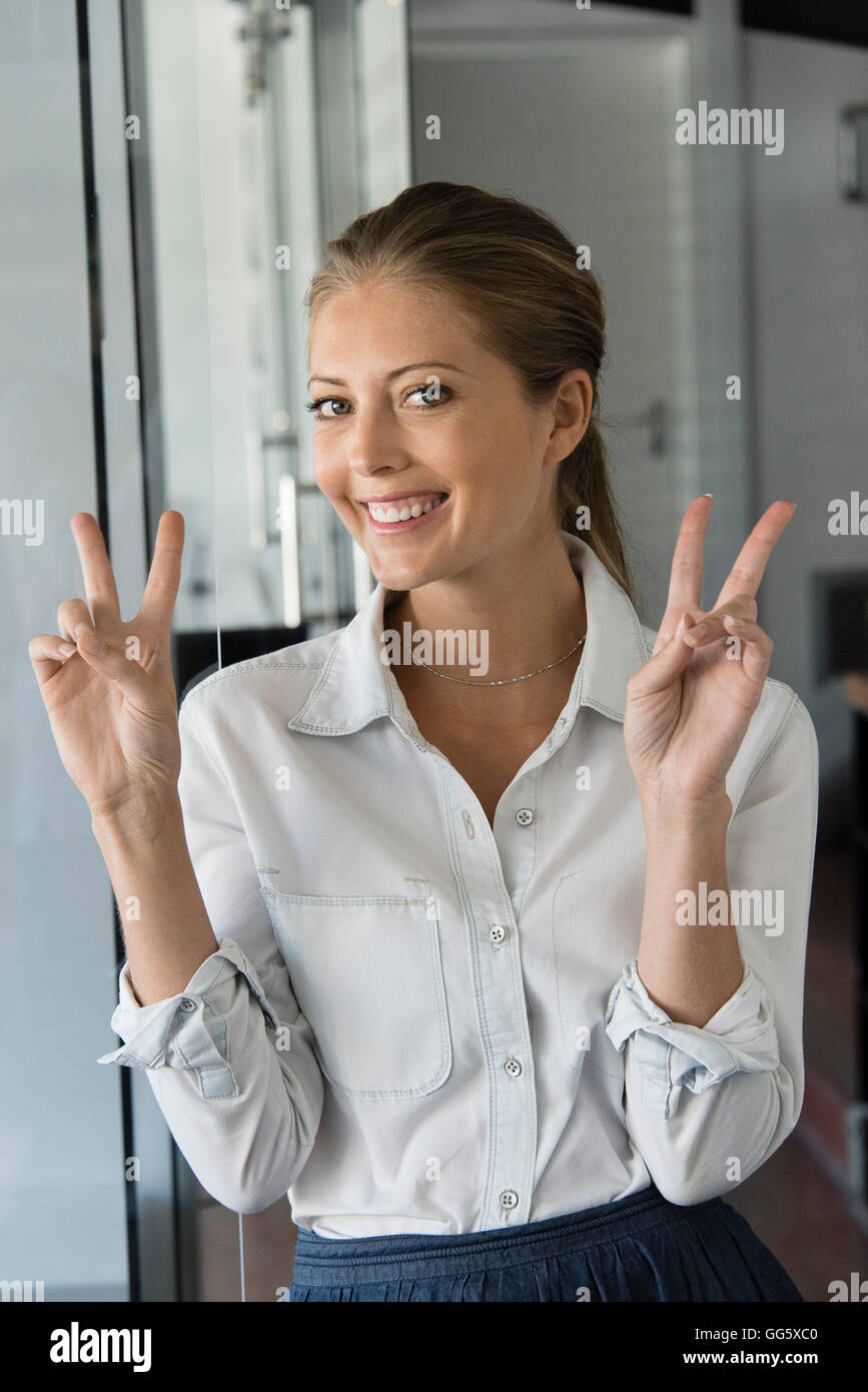 Beautiful woman gesturing peace sign hi-res stock photography and ...