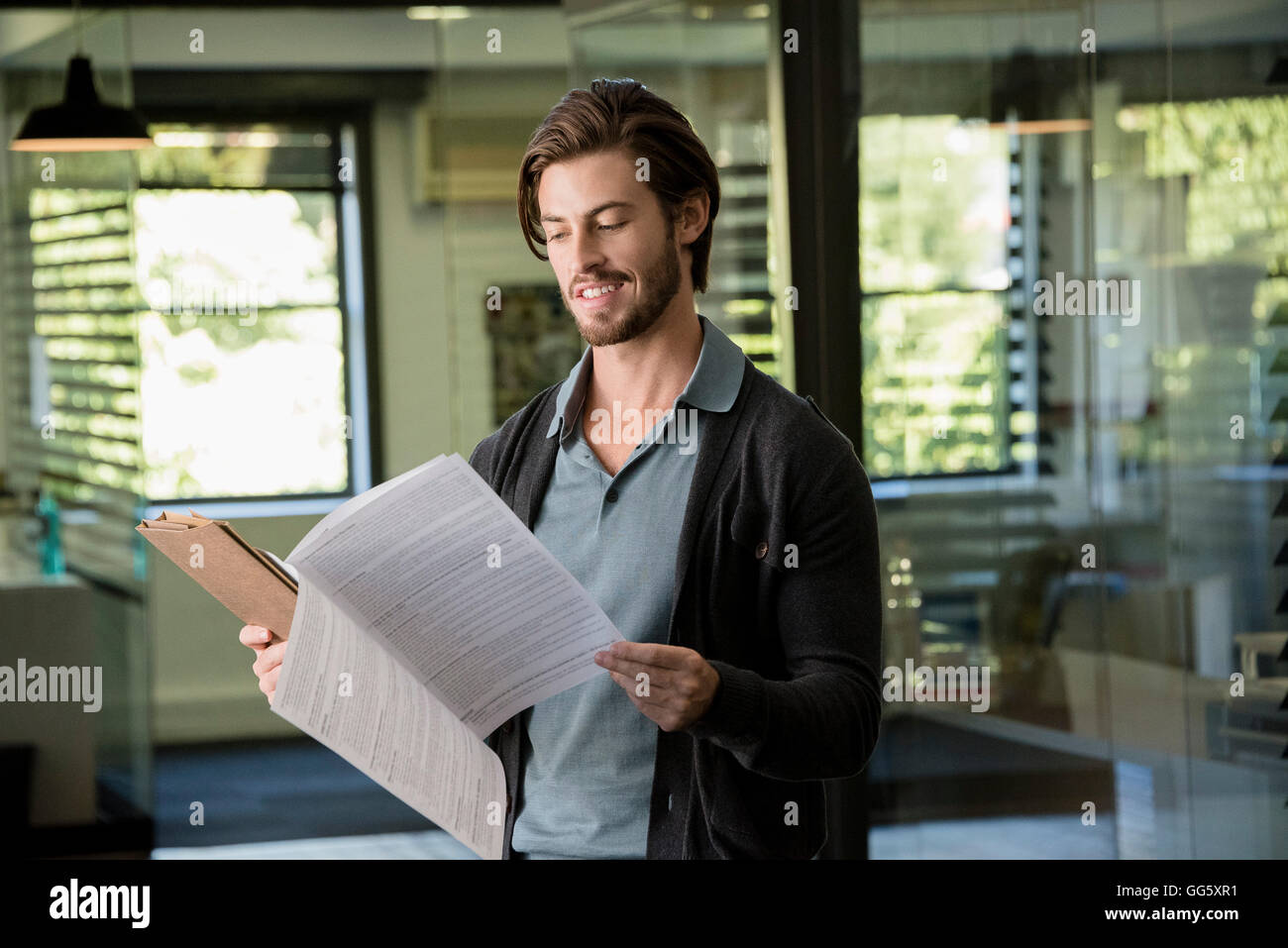 Close-up of a happy man reading a file Stock Photo - Alamy