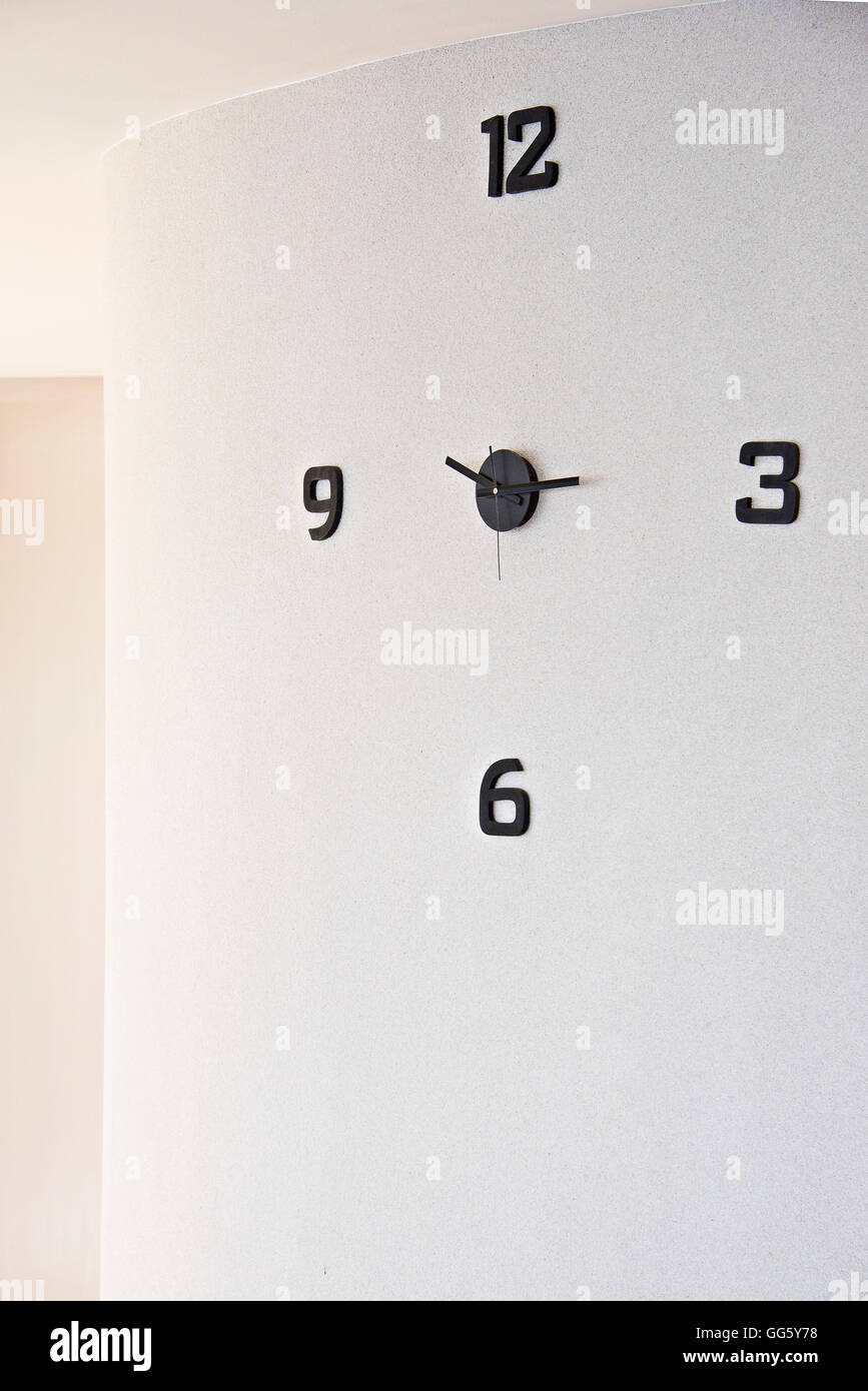 Close-up of wall clock against white wall Stock Photo - Alamy