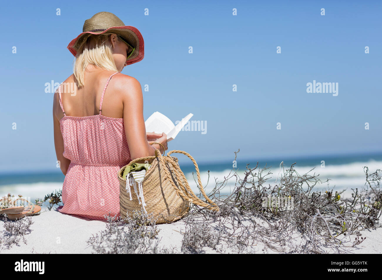 Beautiful woman reading a book o the beach Stock Photo - Alamy