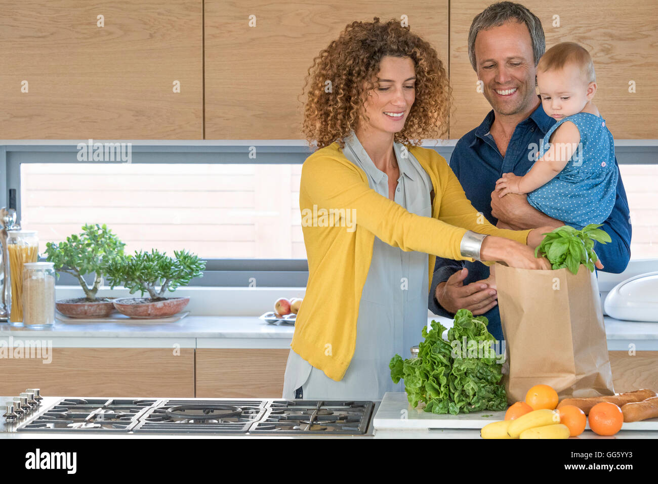 Family taking out food from paper bag in the kitchen Stock Photo - Alamy
