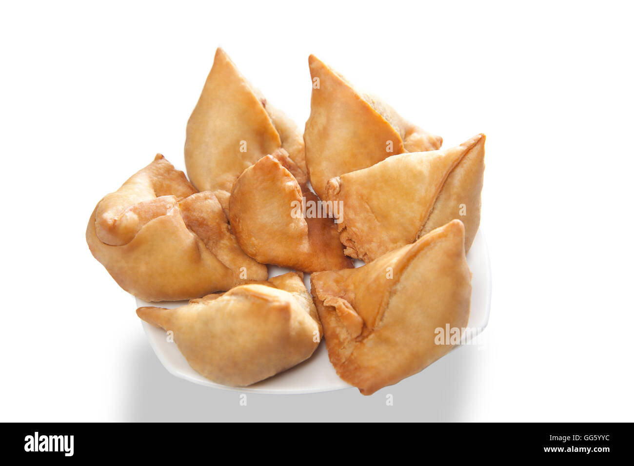 Fresh samosas in plate over white background Stock Photo - Alamy