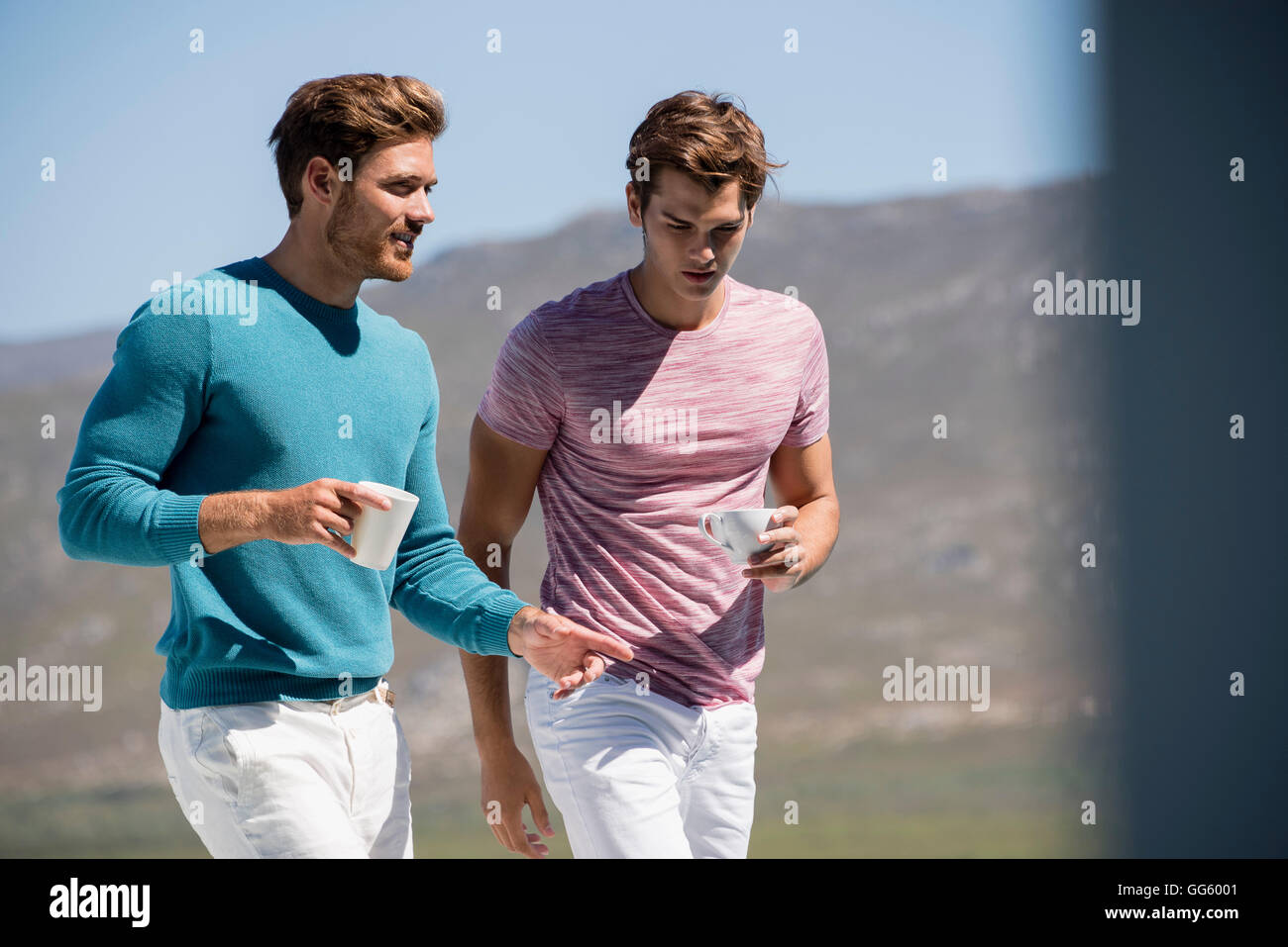 Happy male friends talking with cup of coffee outdoors Stock Photo - Alamy