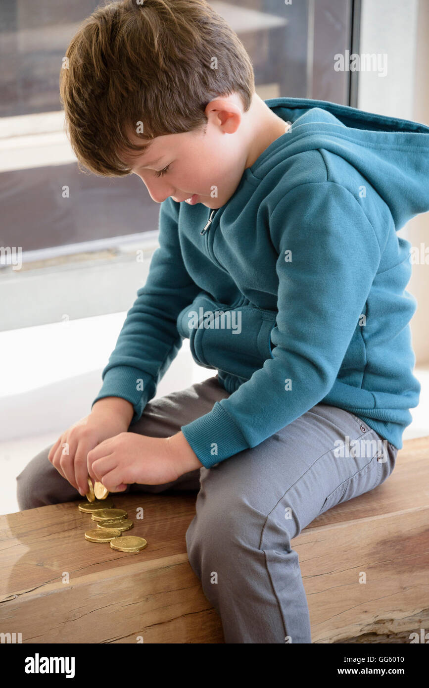 Little boy playing with coins Stock Photo - Alamy