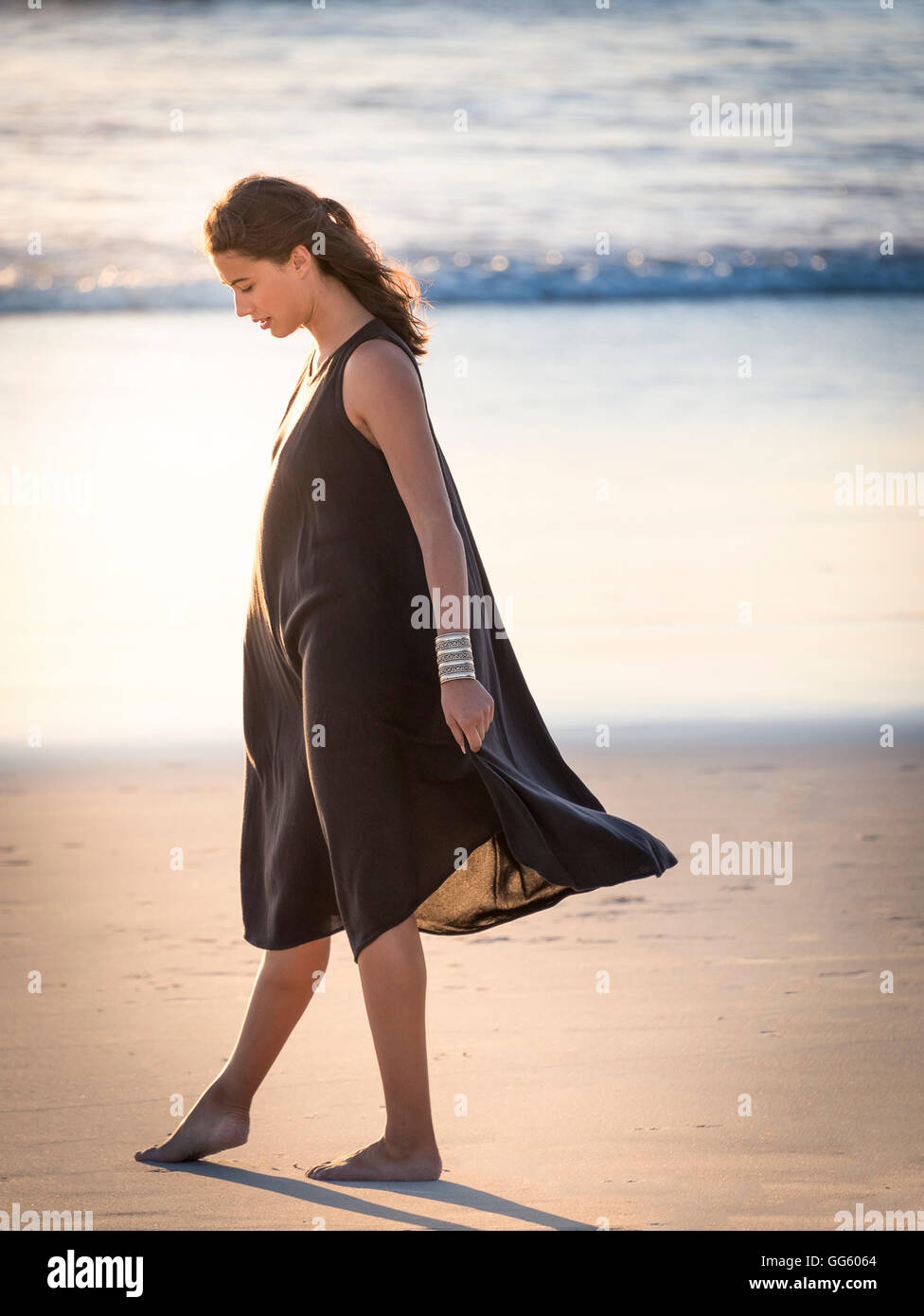 Beautiful young woman walking on the beach Stock Photo - Alamy