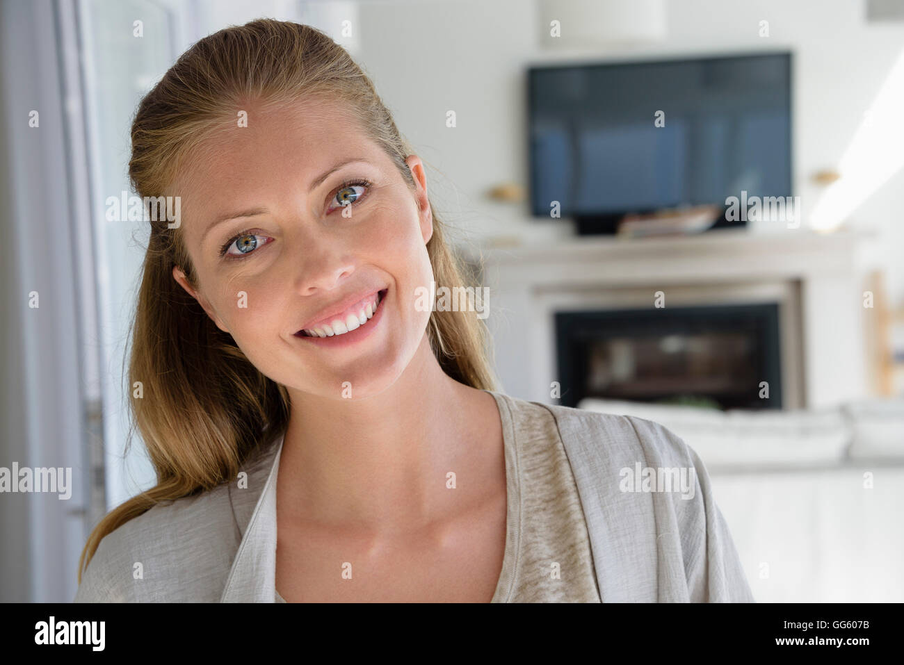 Happy beautiful woman smiling in living room Stock Photo - Alamy