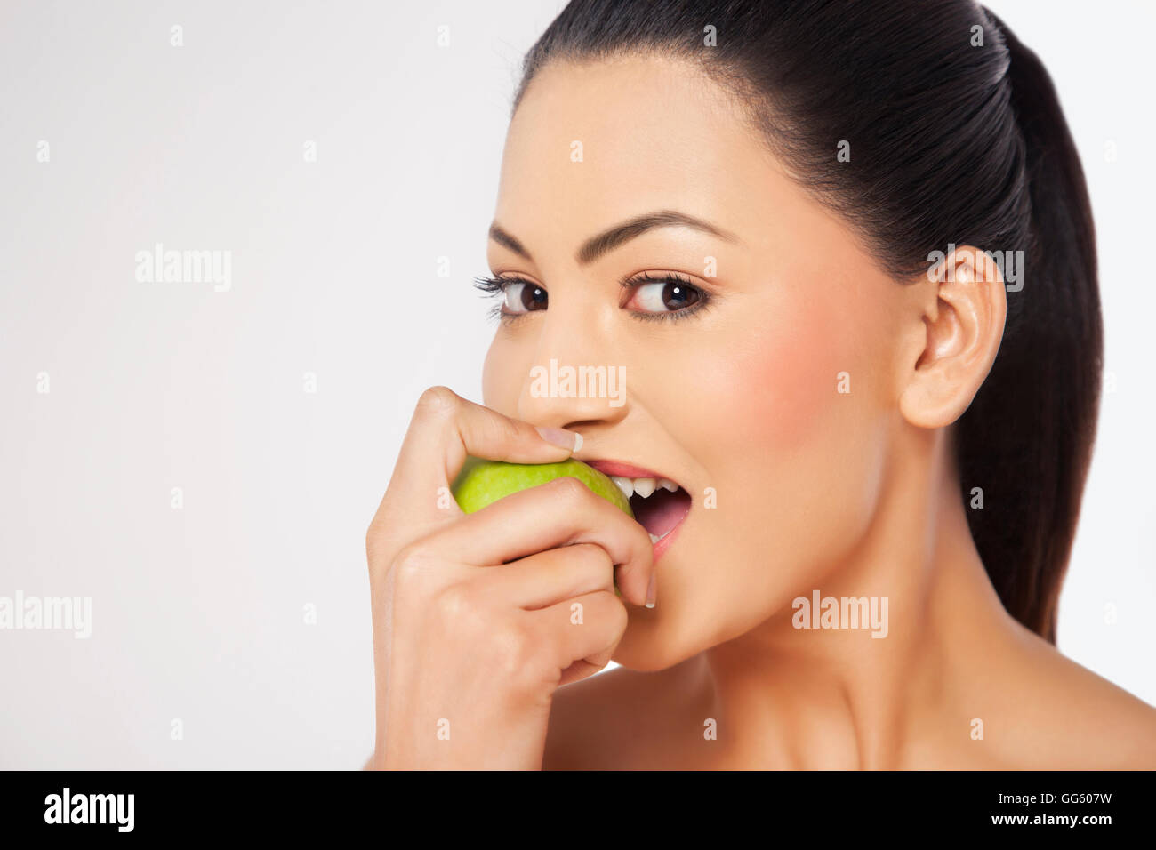 Young woman biting green apple Stock Photo - Alamy