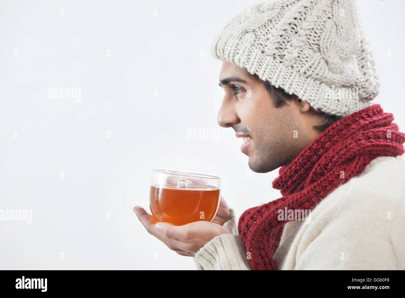 Young man holding tea cup over white background Stock Photo - Alamy