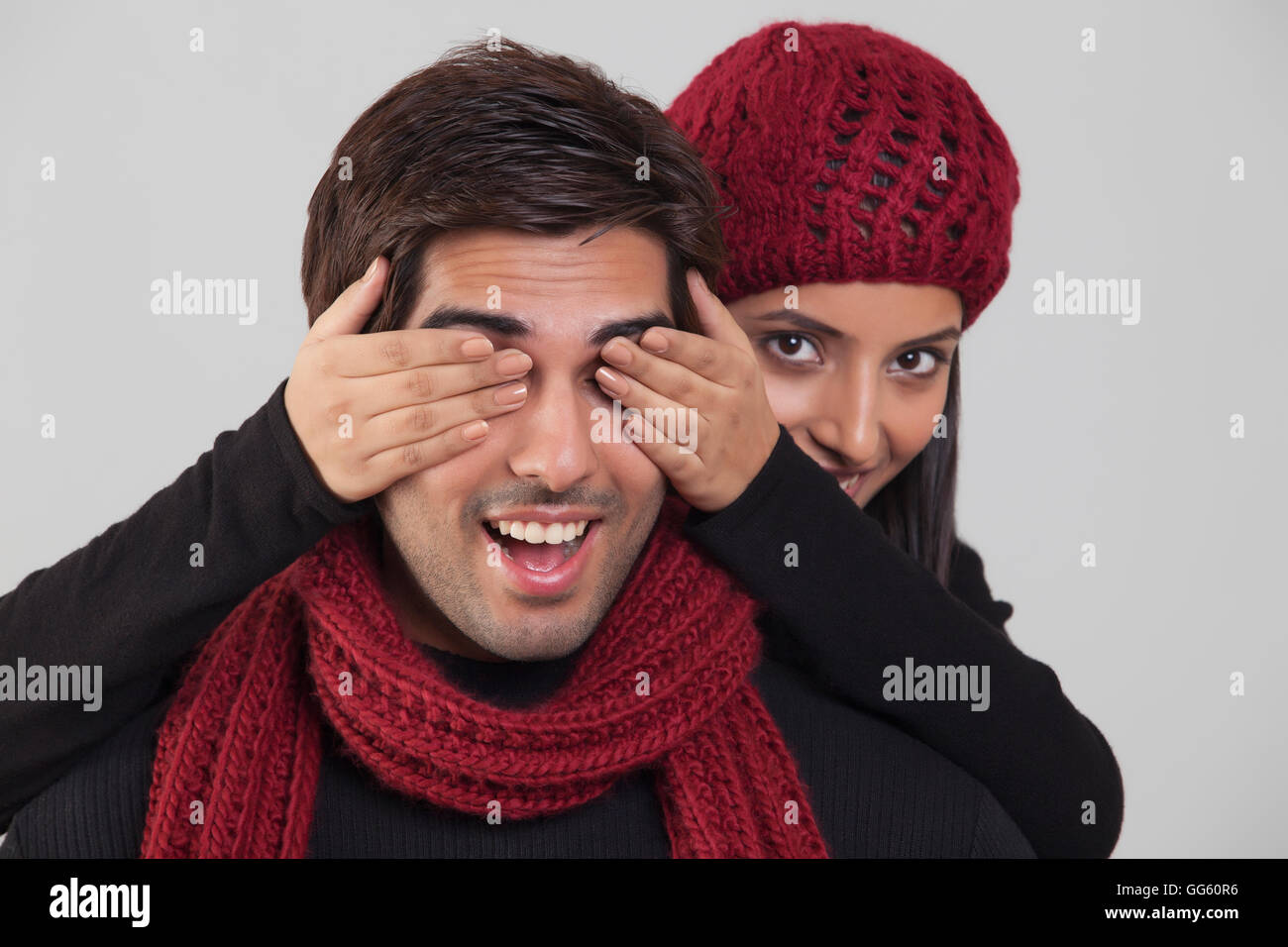 Young woman covering man's eyes Stock Photo - Alamy