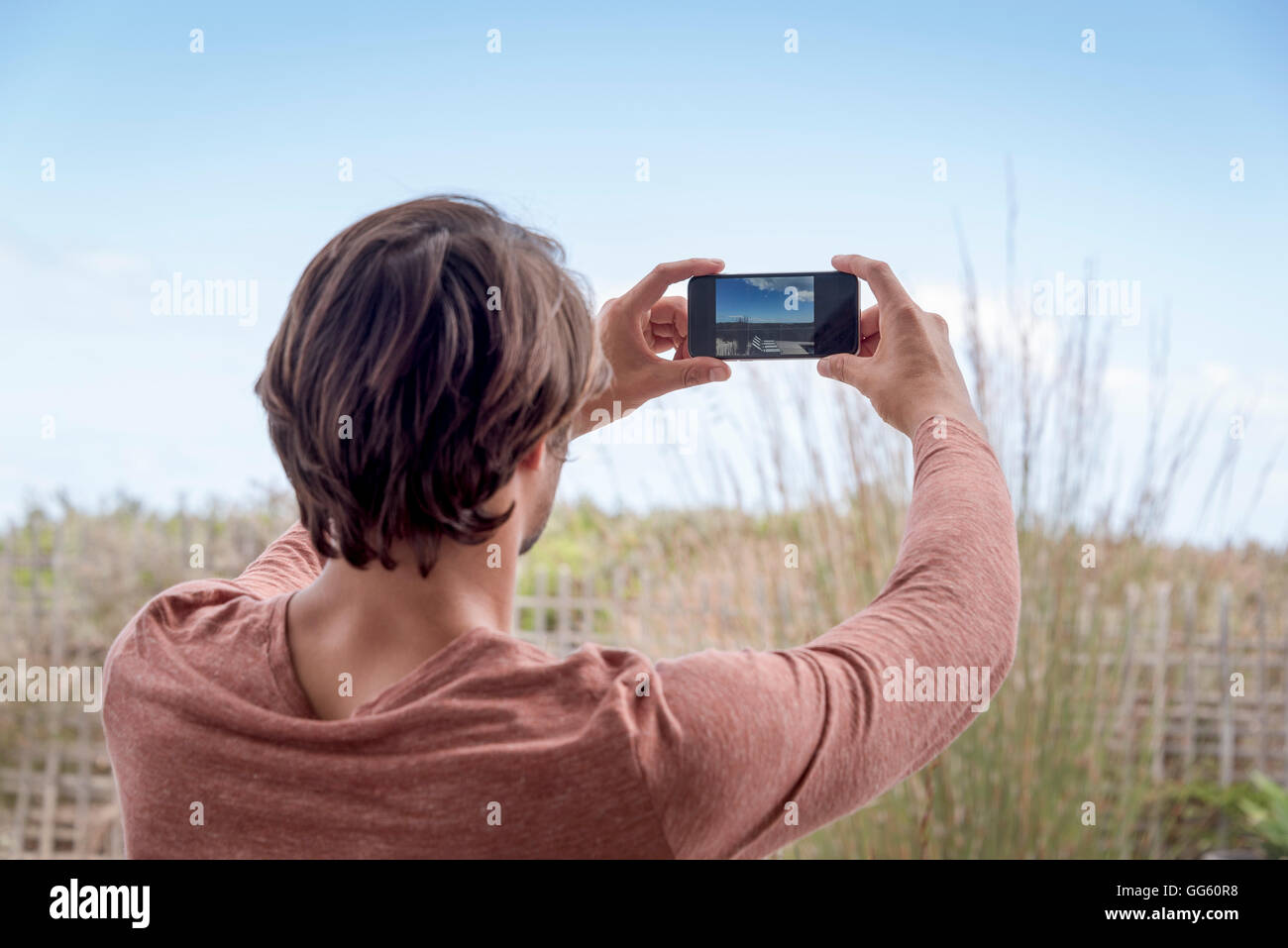 Young man taking a picture with camera phone Stock Photo - Alamy