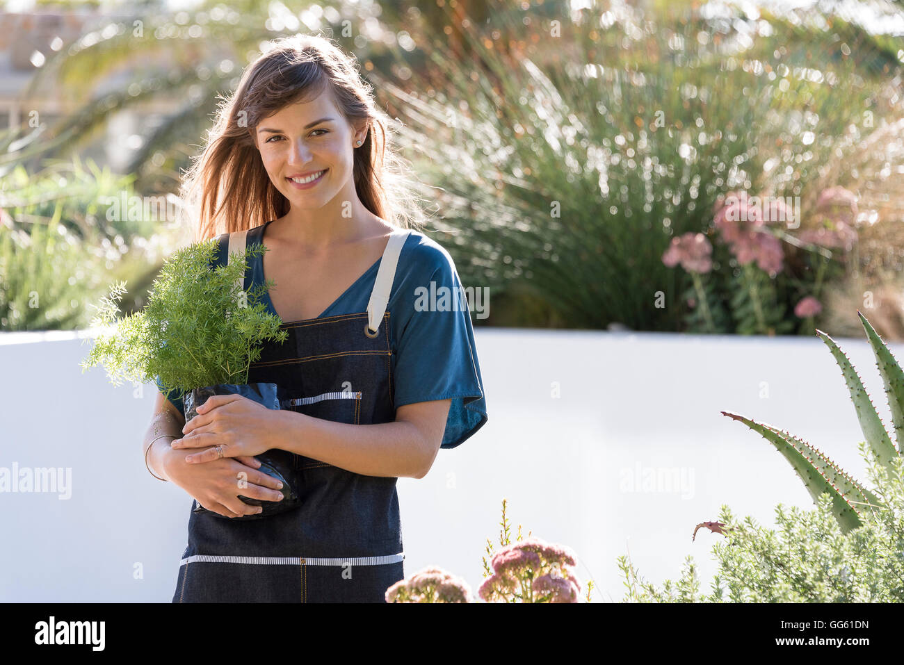 Portrait of a beautiful young woman gardening Stock Photo - Alamy