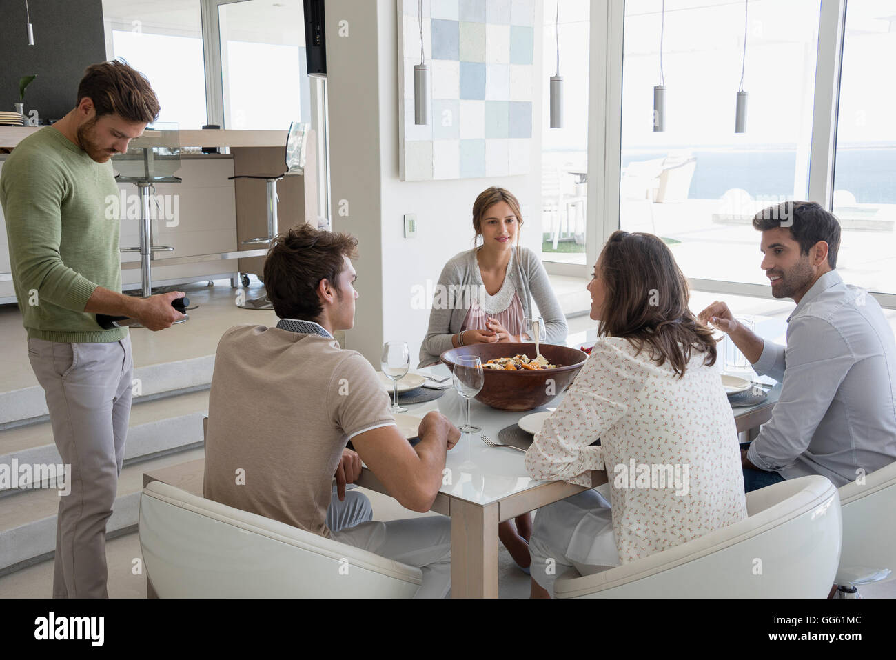 Group of friends sitting at dining table Stock Photo - Alamy