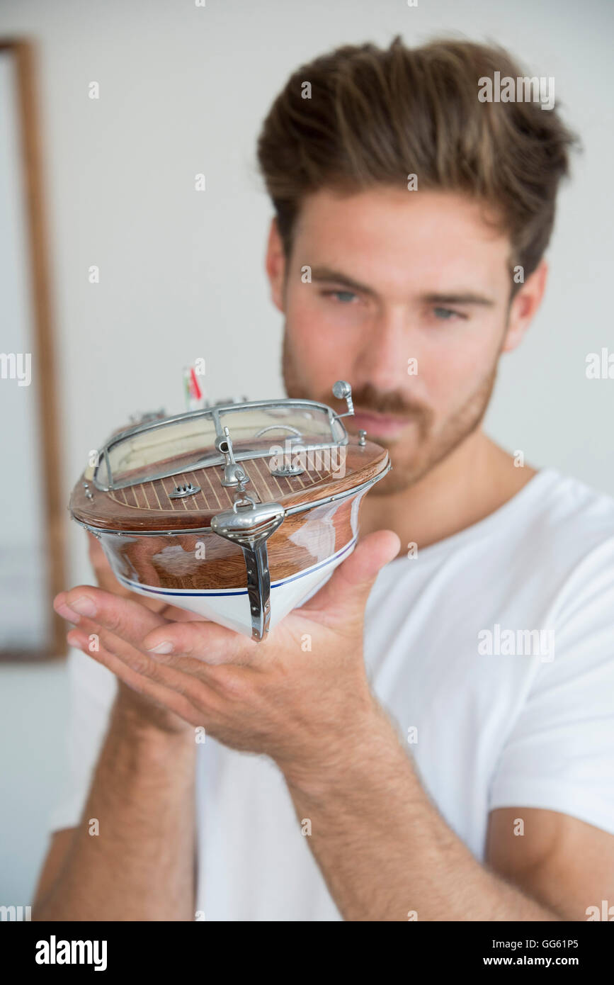 Young man holding a model boat Stock Photo - Alamy