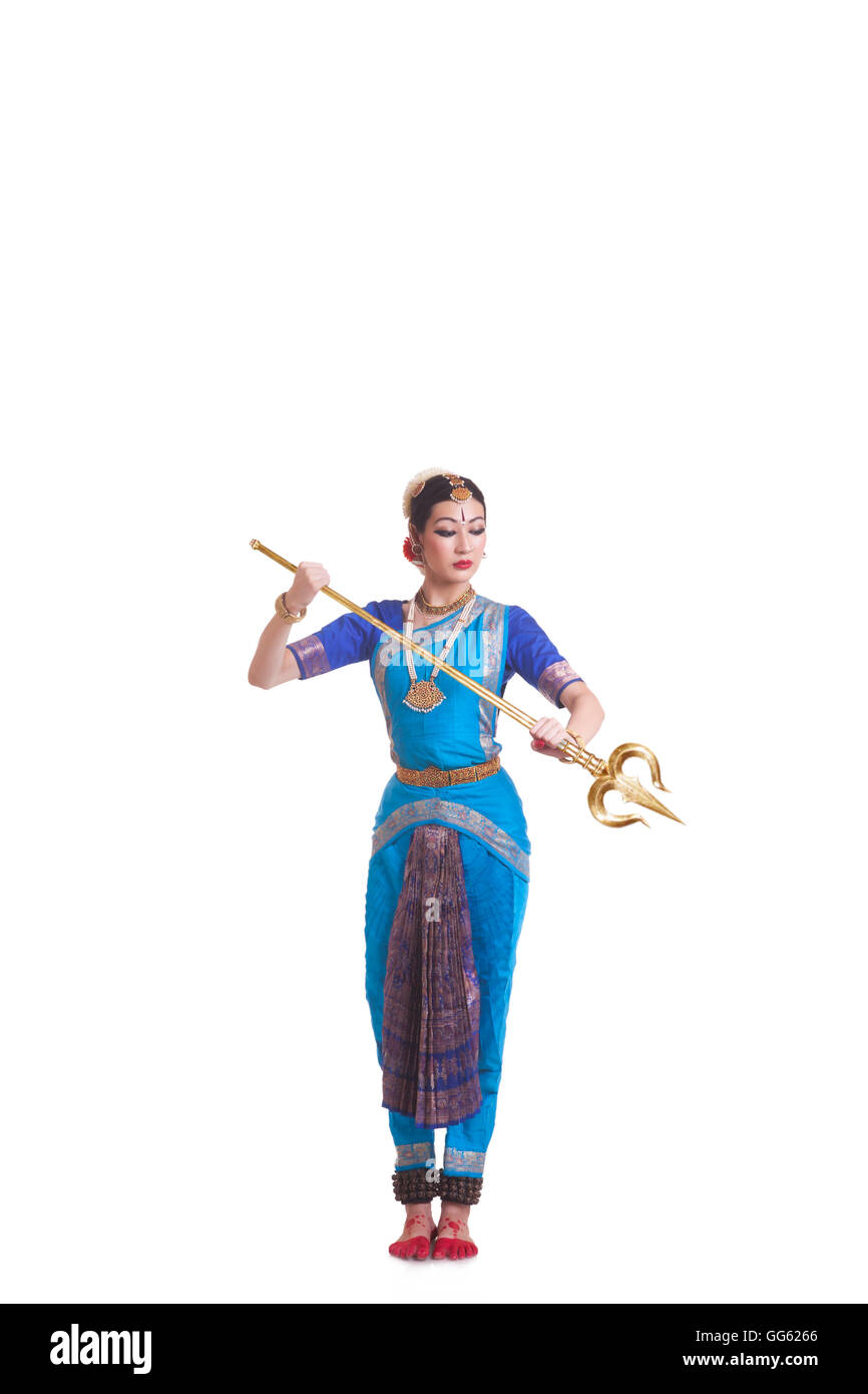 Full length of dancer holding trident while performing Bharatanatyam ...
