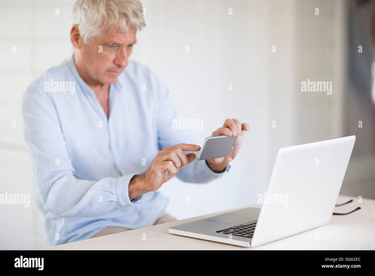 Senior man photographing laptop screen with camera phone Stock Photo ...
