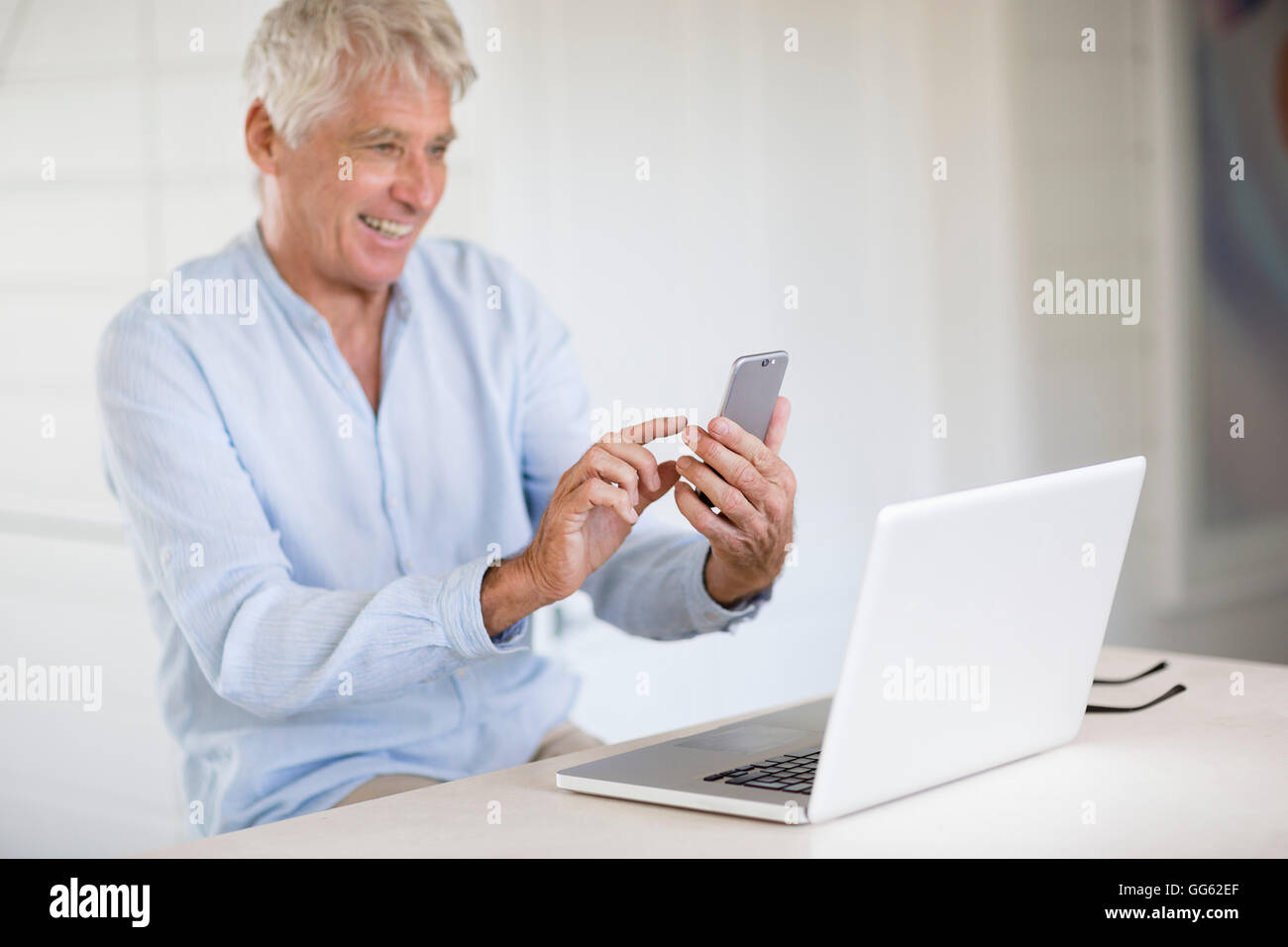 Happy senior man photographing laptop screen with camera phone Stock ...