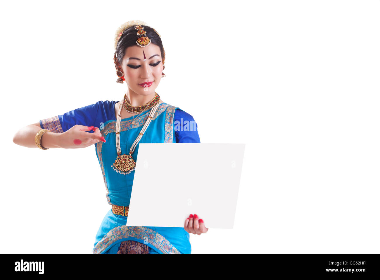 Bharatanatyam dancer pointing at blank placard over white background ...