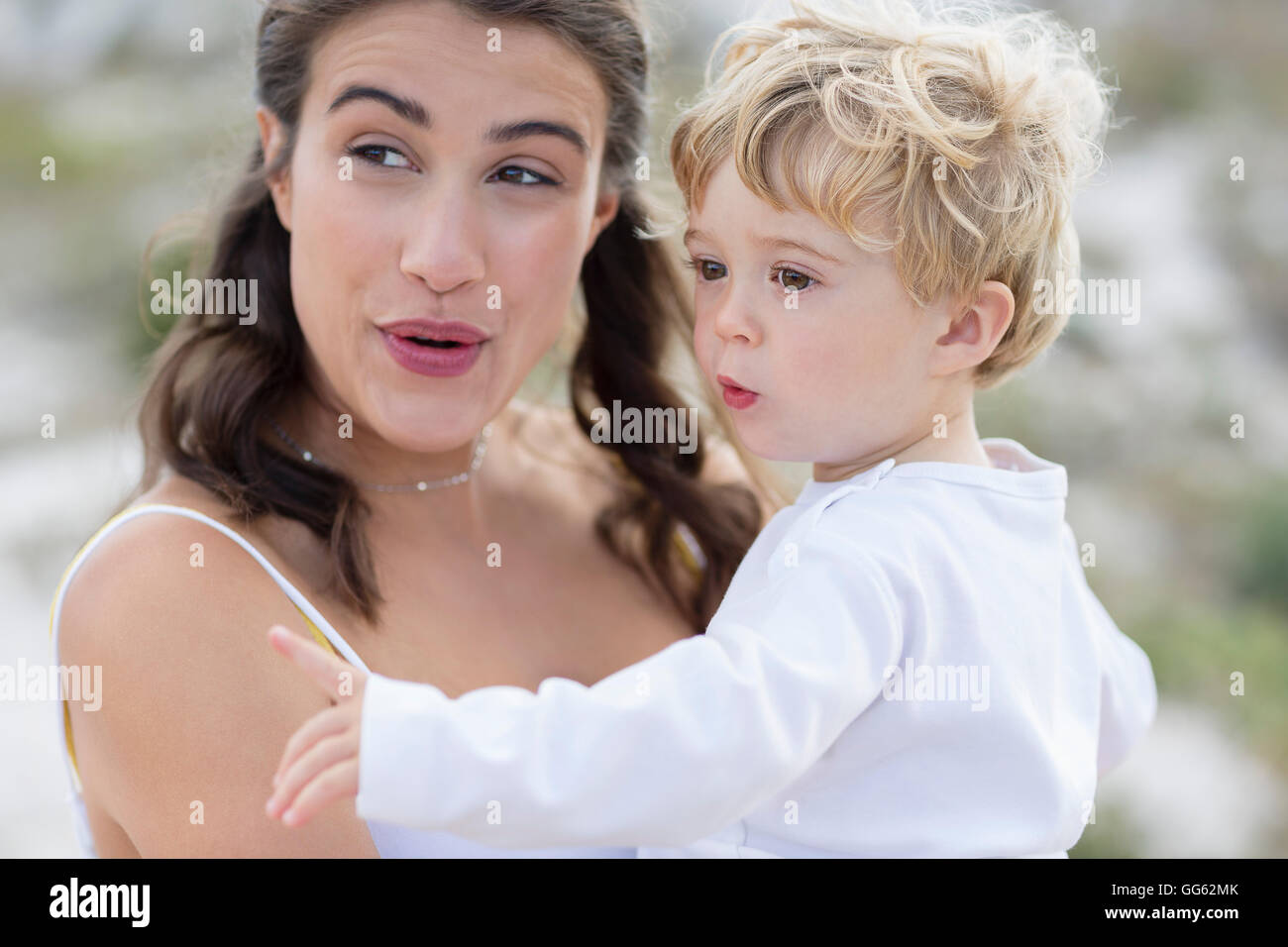 Close-up of a beautiful woman with her baby pointing Stock Photo - Alamy