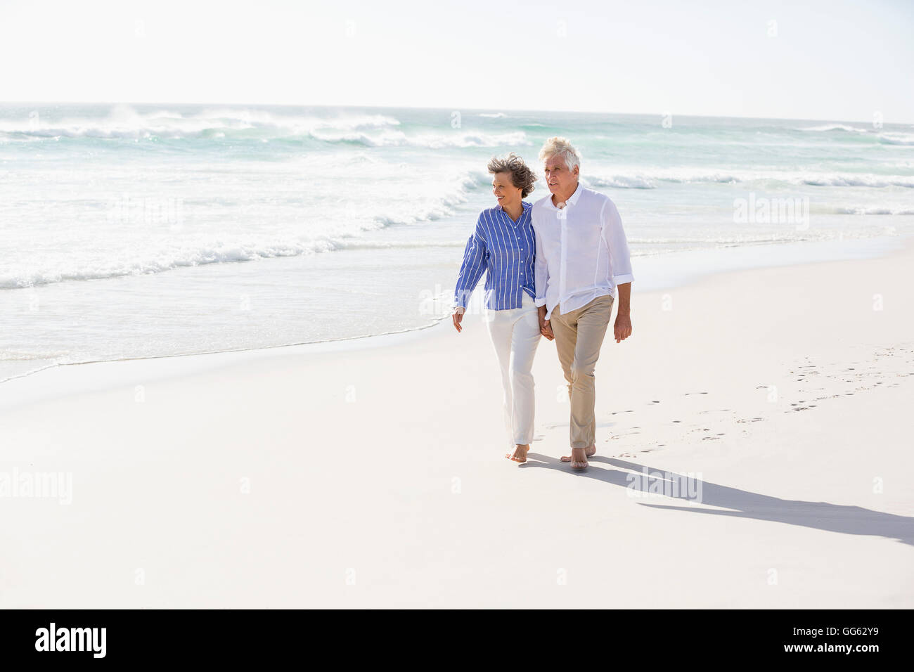 Couple walking on the beach Stock Photo - Alamy