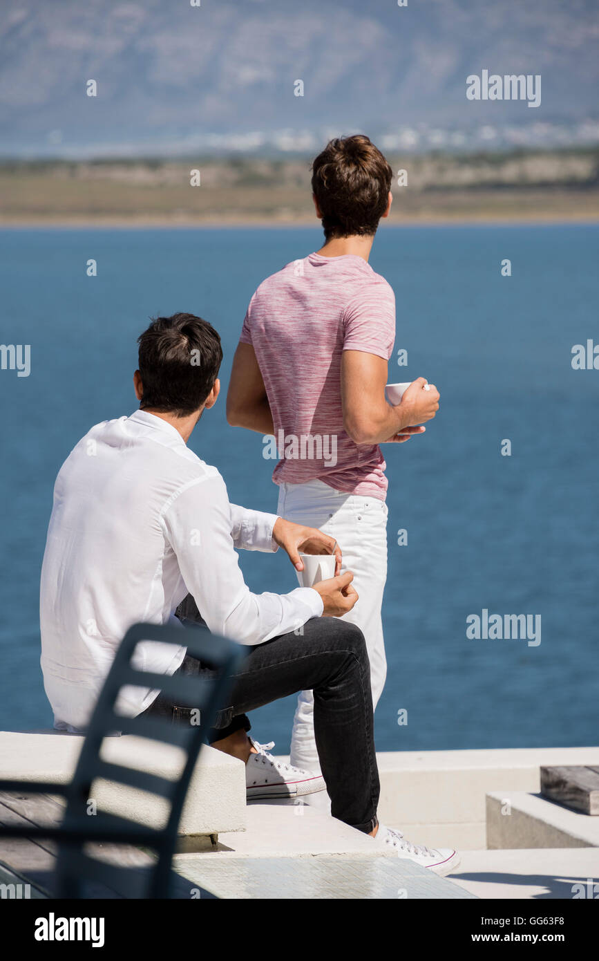 Two male friends enjoying coffee together outdoors Stock Photo - Alamy