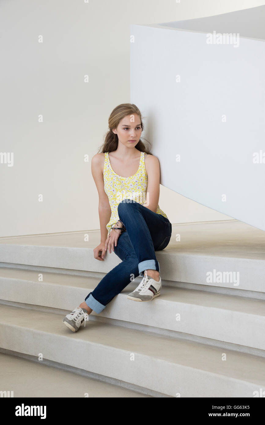 Teenage girl sitting on steps and thinking Stock Photo - Alamy