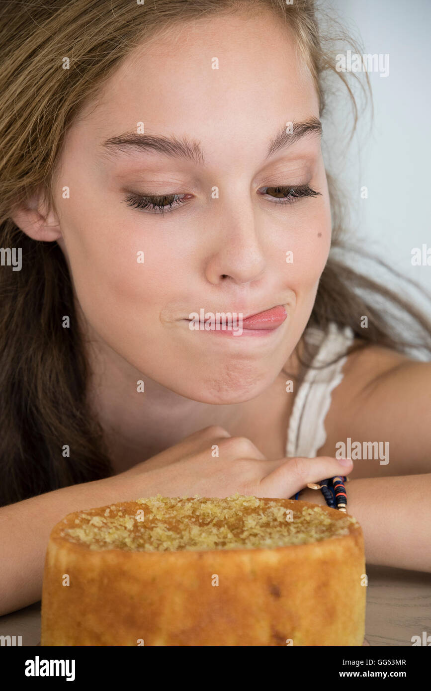 Beautiful teenage girl looking at cake Stock Photo - Alamy