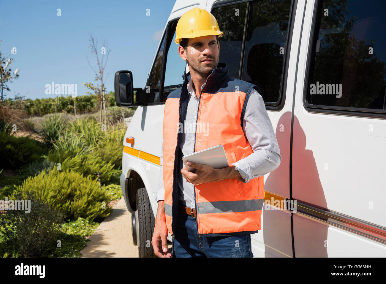Male engineer with a digital tablet standing by van Stock Photo - Alamy